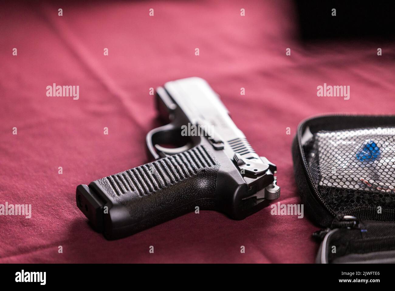 Gun laying in the middle of a maroon cleaning cloth with kit Stock ...