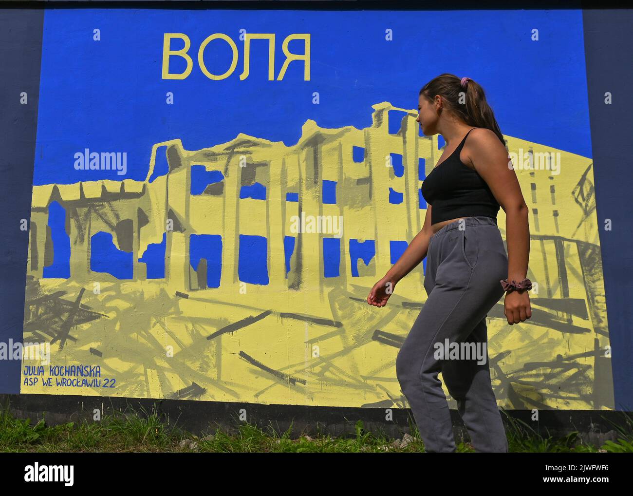 GDANSK, POLAND. 05 September 2022. Young woman walks by a pro-Ukrainian ...