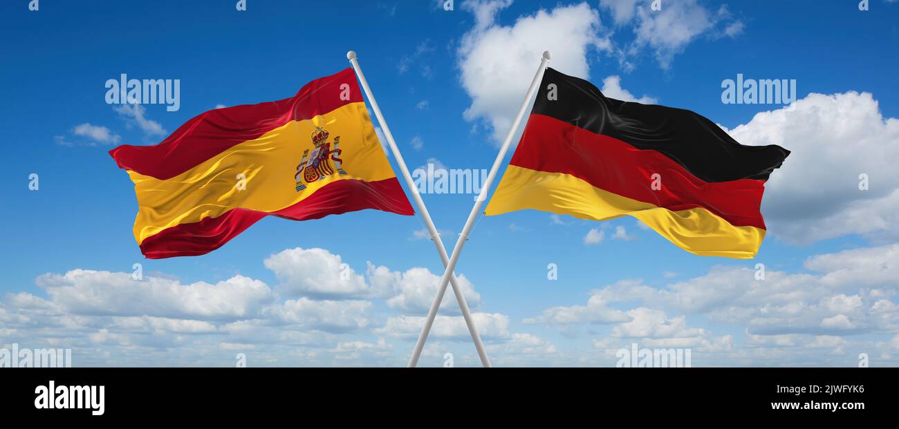 two crossed flags Federal Republic of Germany and spain waving in wind ...