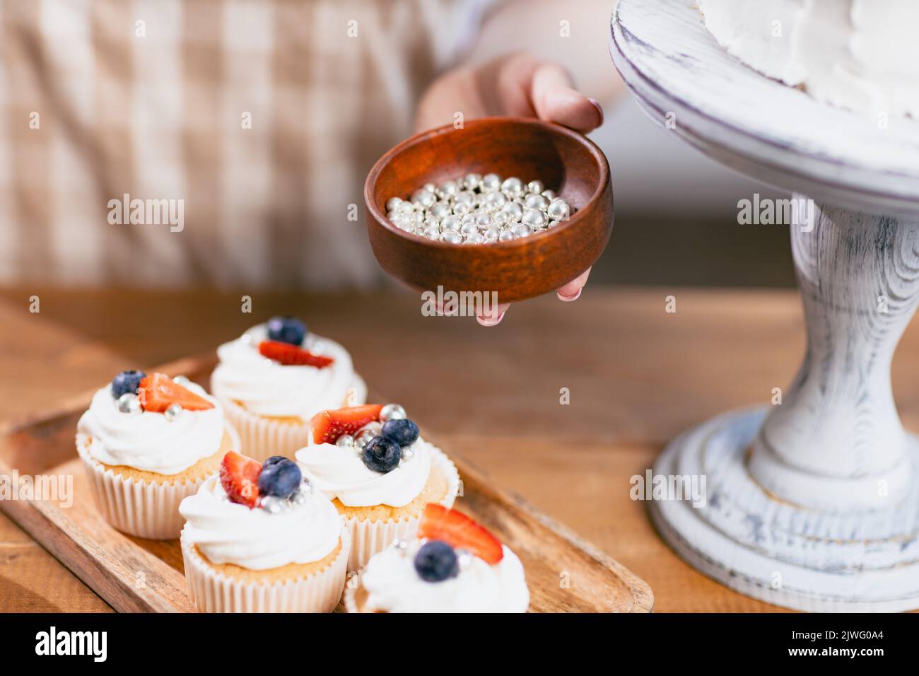 Pastry chef confectioner young caucasian woman decorate sweet balls ...