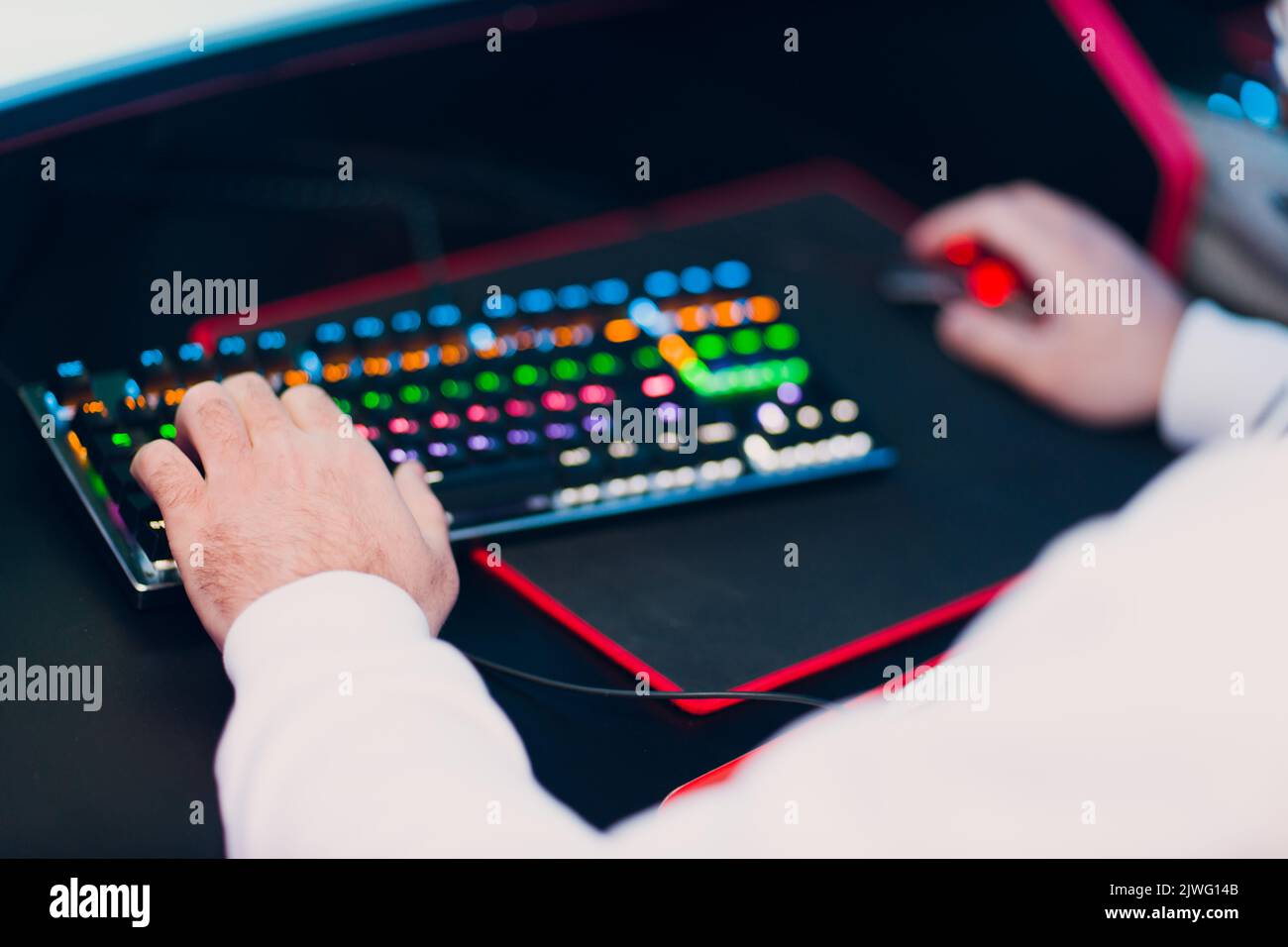 Guy playing gaming game on computer keyboard close up hands at club ...