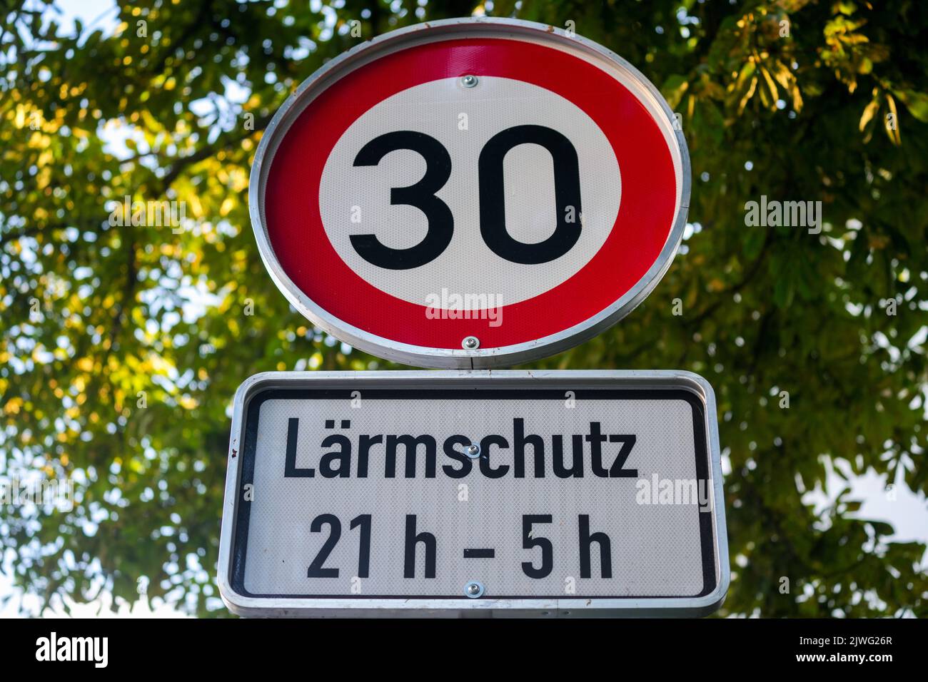 A round red traffic sign showing 30 speed limit over a sign that says ...