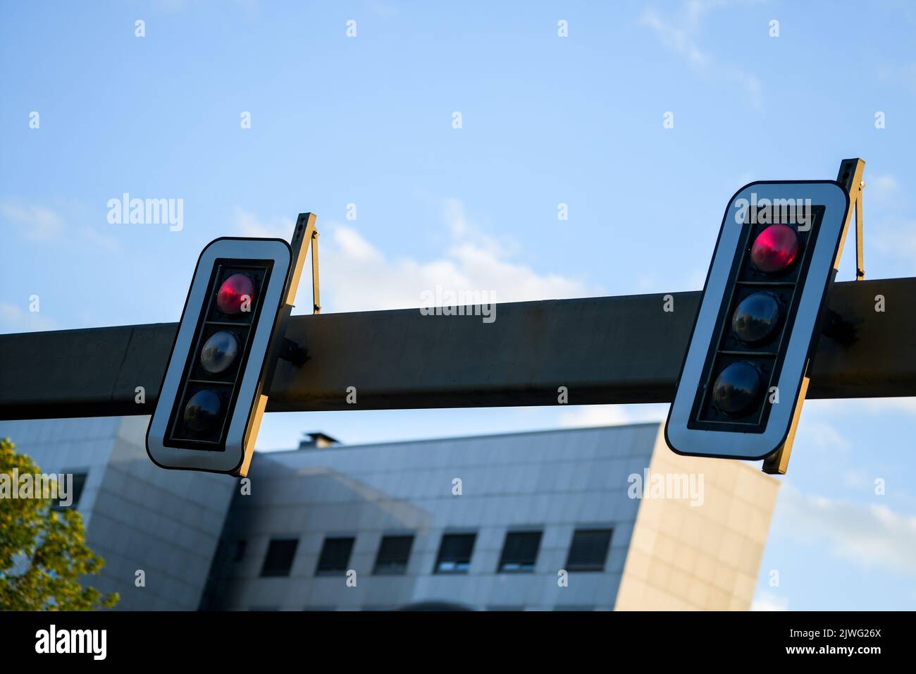 A low angle shot of two traffic lights on a metal display showing red ...