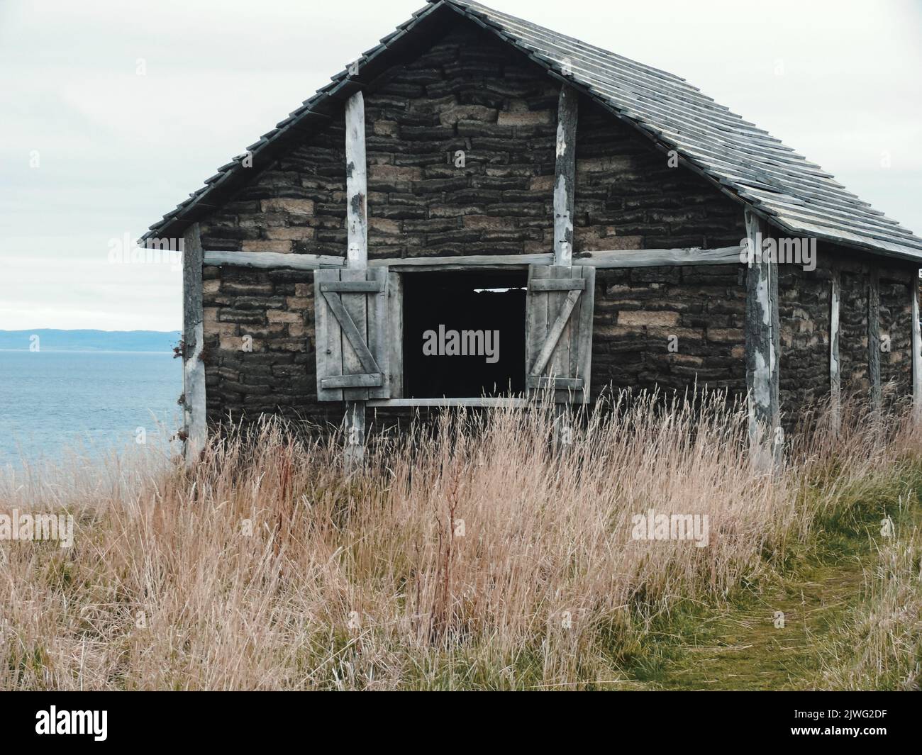 An old wooden house in Bulnes Fort, Punta Arenas, Chile with sea in the ...