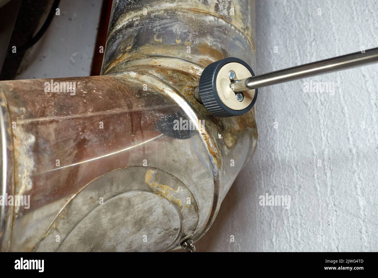 A closeup shot of a gold-colored heating control with a silver stick ...