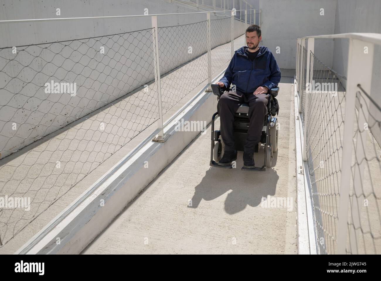Man in a wheelchair use an accessible ramp Stock Photo - Alamy