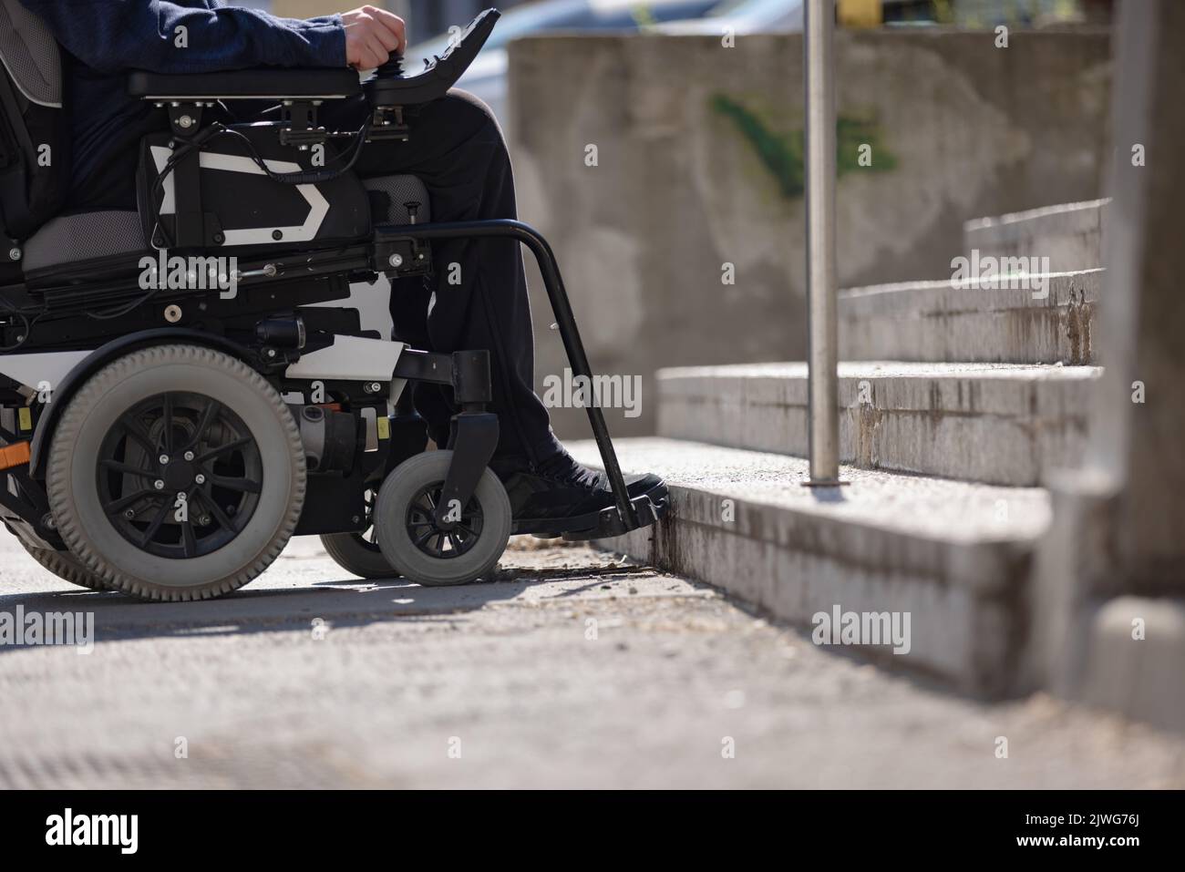 Person with disability on electric wheelchair stopping at the bottom of ...