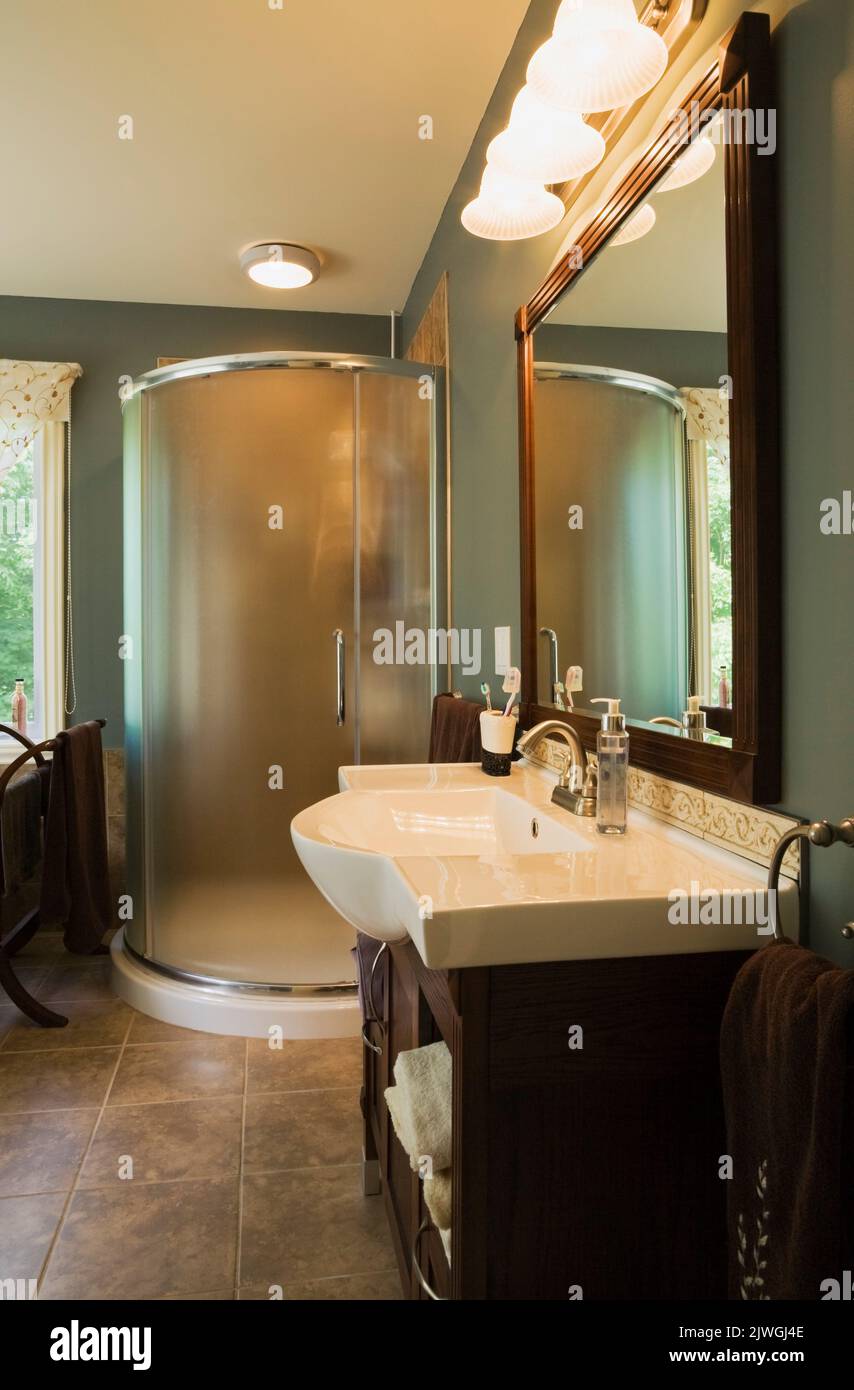 Main bathroom with porcelain countertop sink and glass shower stall ...