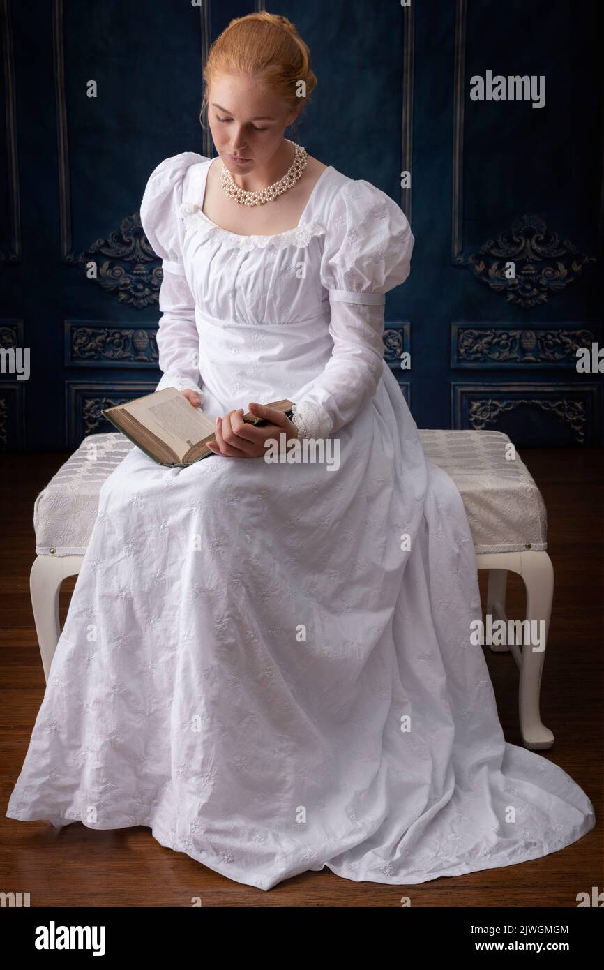 A Regency woman wearing a white embroidered muslin gown with a pearl ...