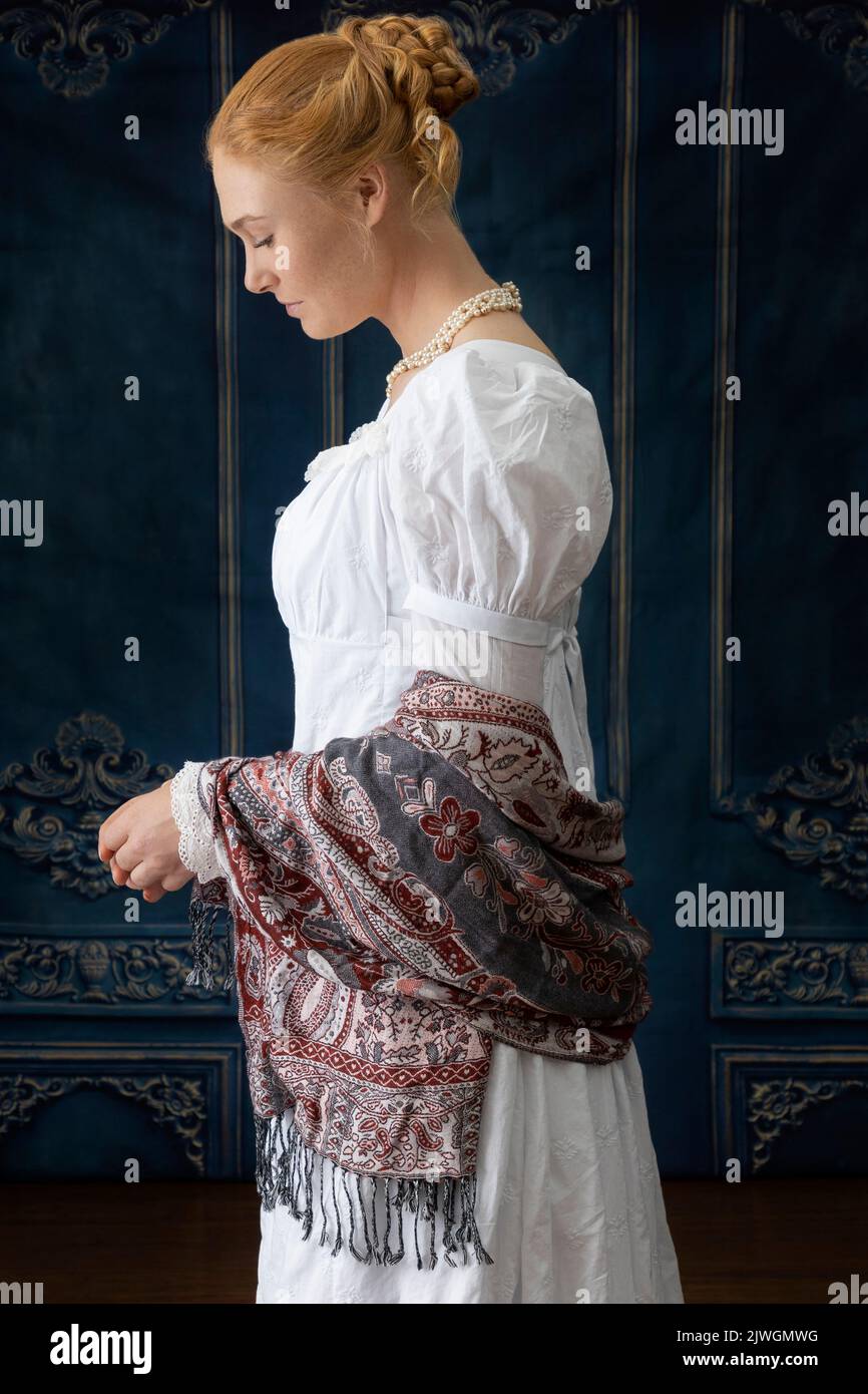 A Regency woman wearing a white embroidered muslin gown with a pearl ...