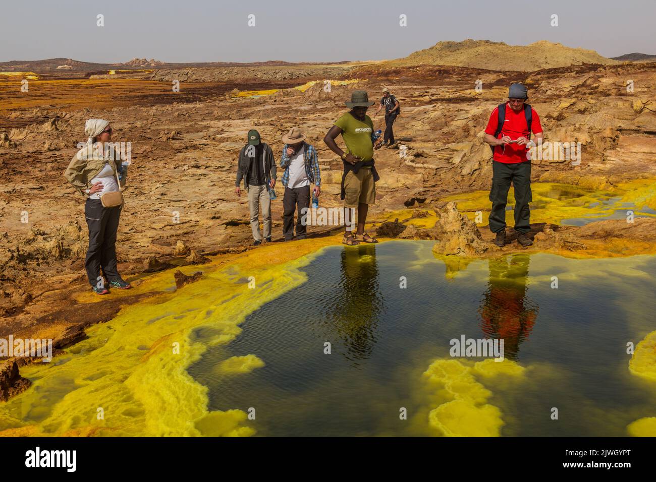 DANAKIL, ETHIOPIA - MARCH 24, 2019: Tourists observe colorful sulfuric ...