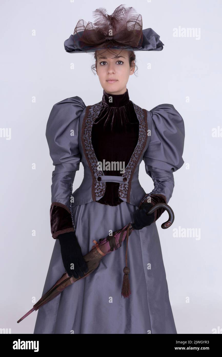 A Victorian woman wearing a silk ensemble with leg o mutton sleeves ...