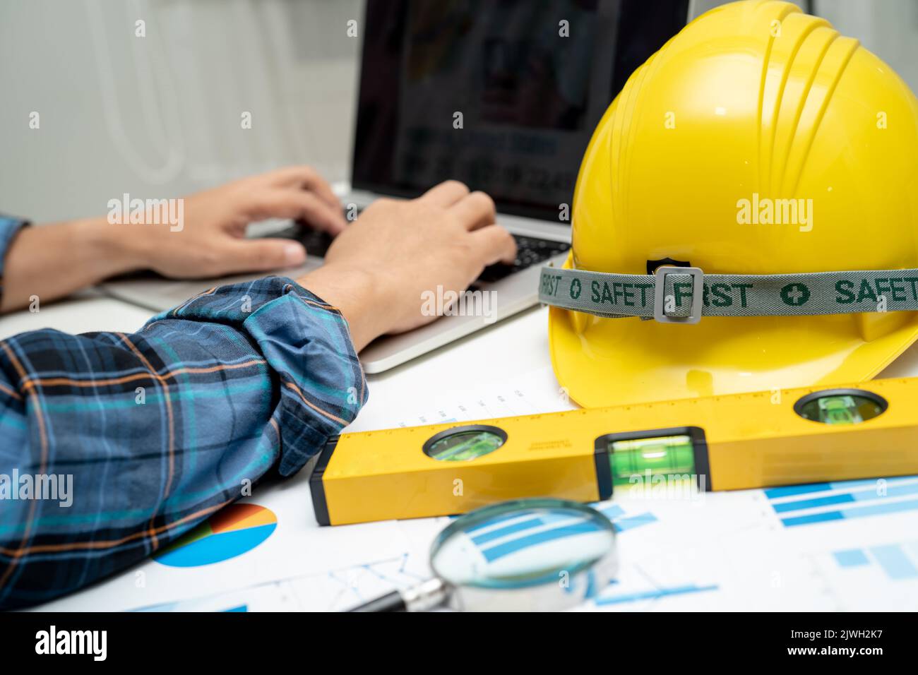 Asian engineer with architectural house plan project blueprint, graph ...