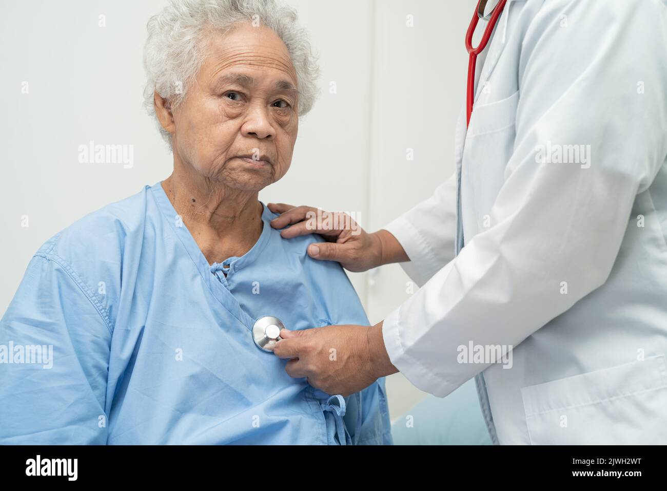 Doctor with stethoscope checking senior or elderly old lady woman ...