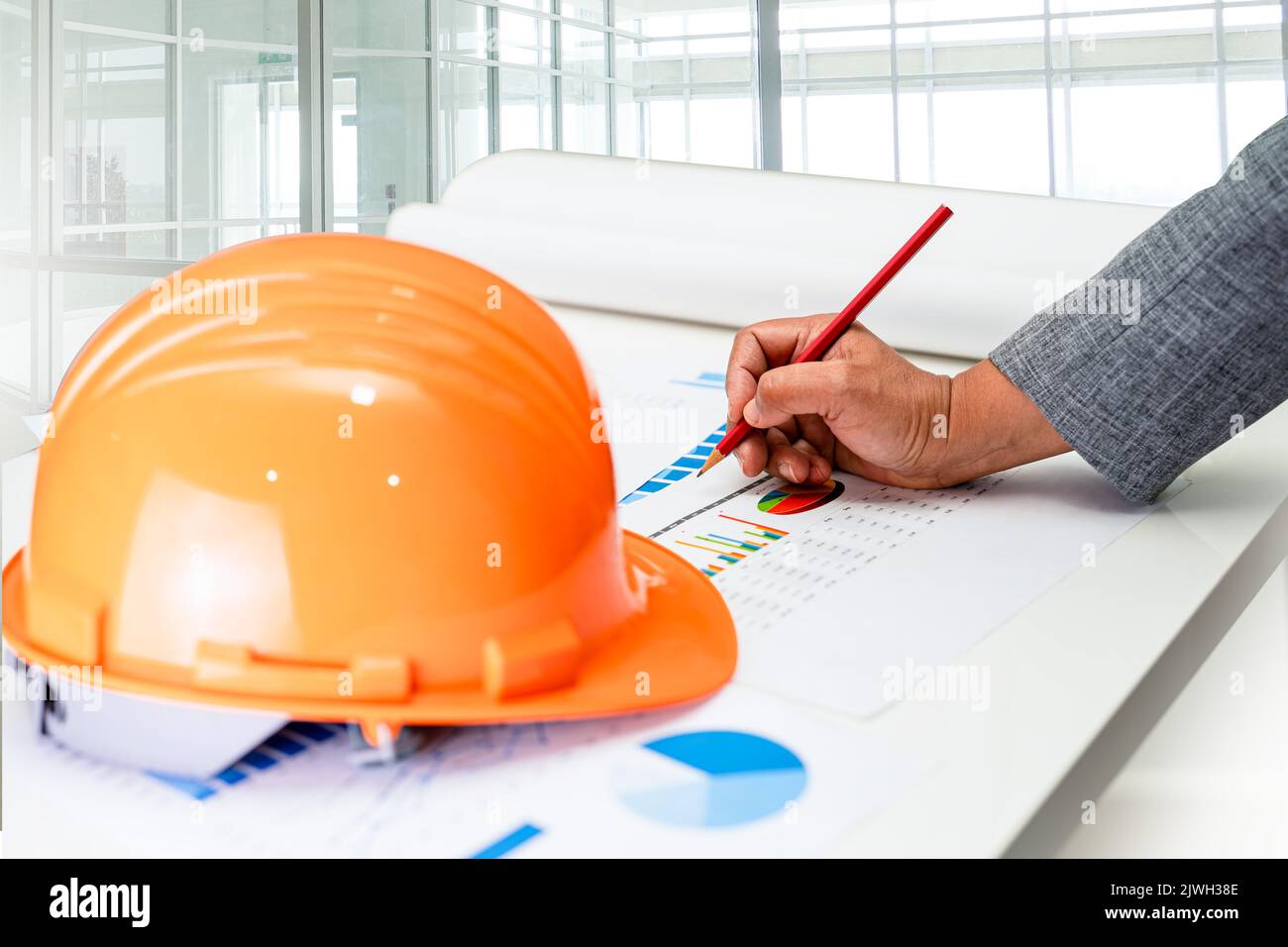 Asian engineer with architectural house plan project blueprint, graph ...