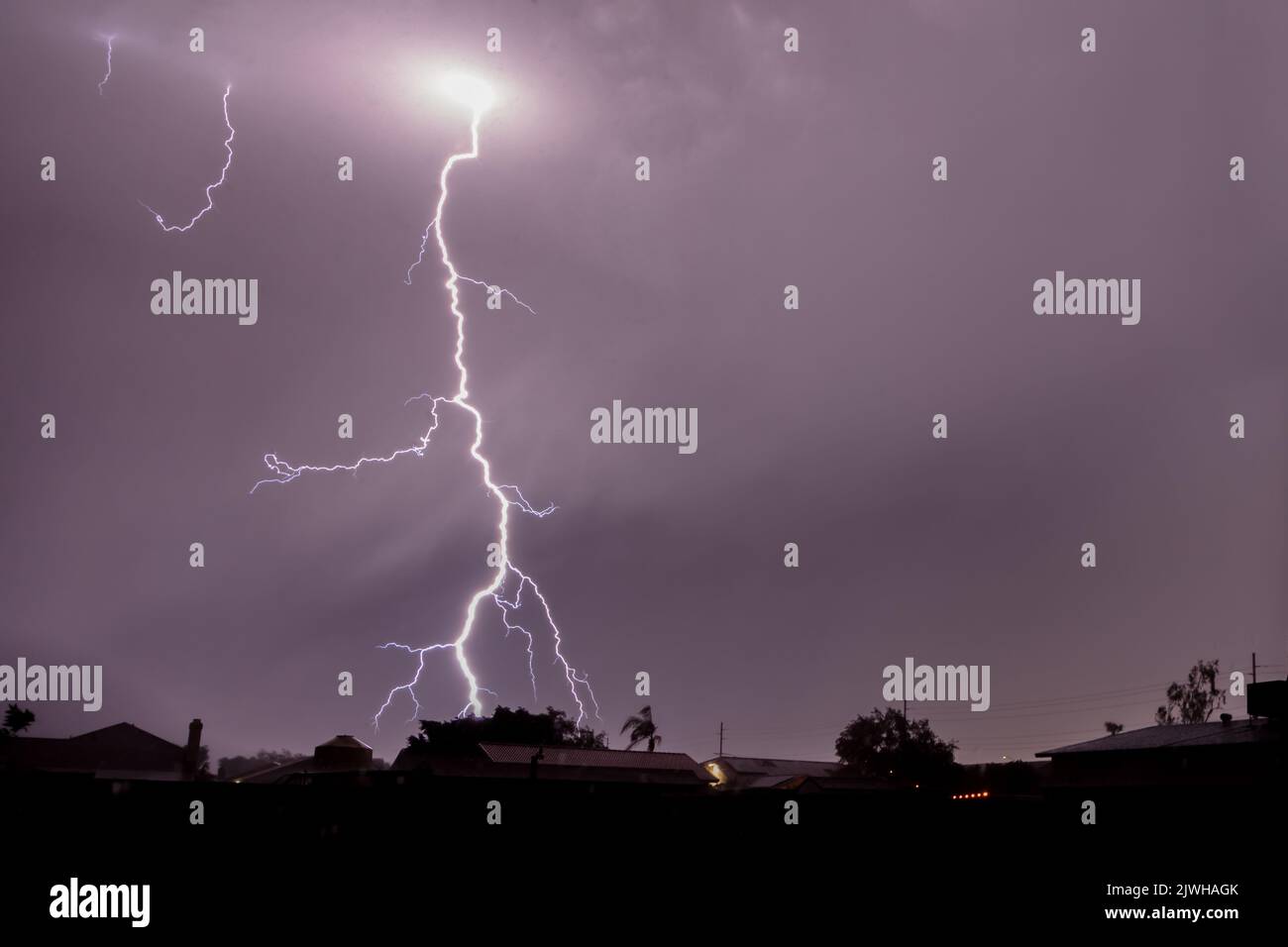 Lightning in Arizona over Phoenix. Colored overcast clouds; Bright spot ...