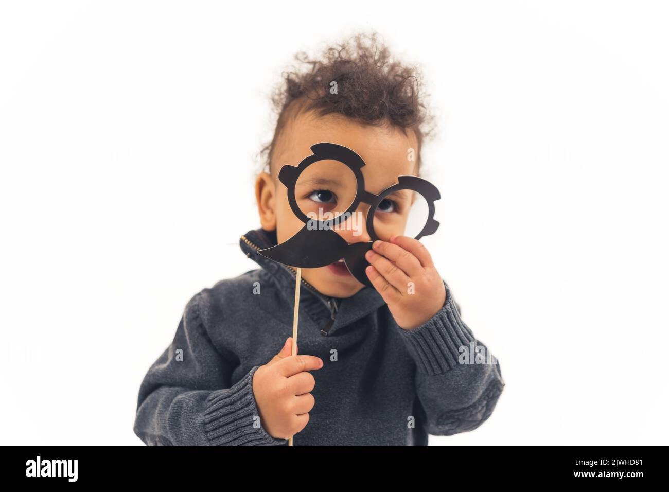 Afro-American toddler holding paper-made mustache and glasses, medium ...