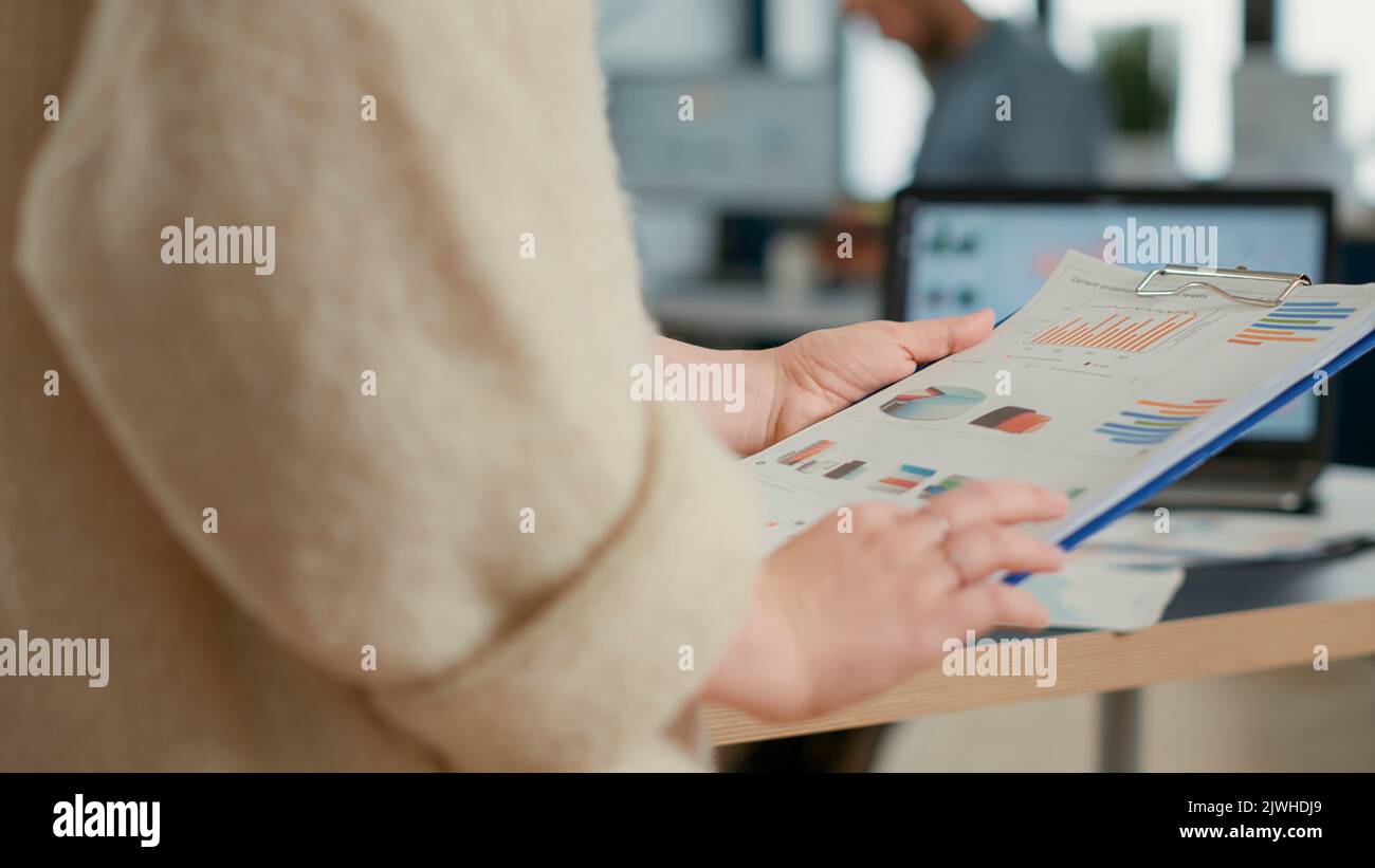 Closeup of woman hands holding clipboard with papers looking at pie ...
