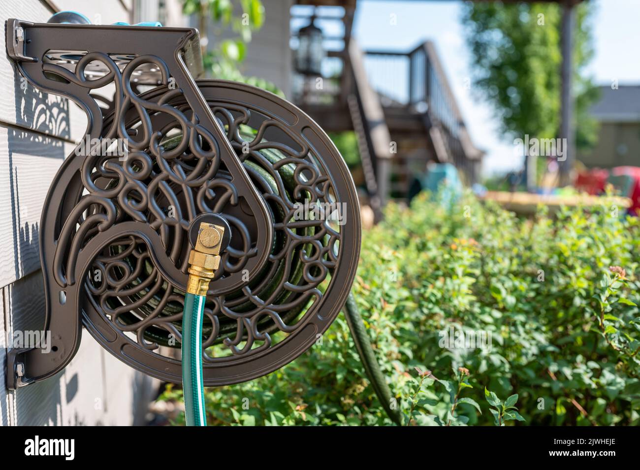 Decorative metal hose storage wheel mounted on the exterior of a ...