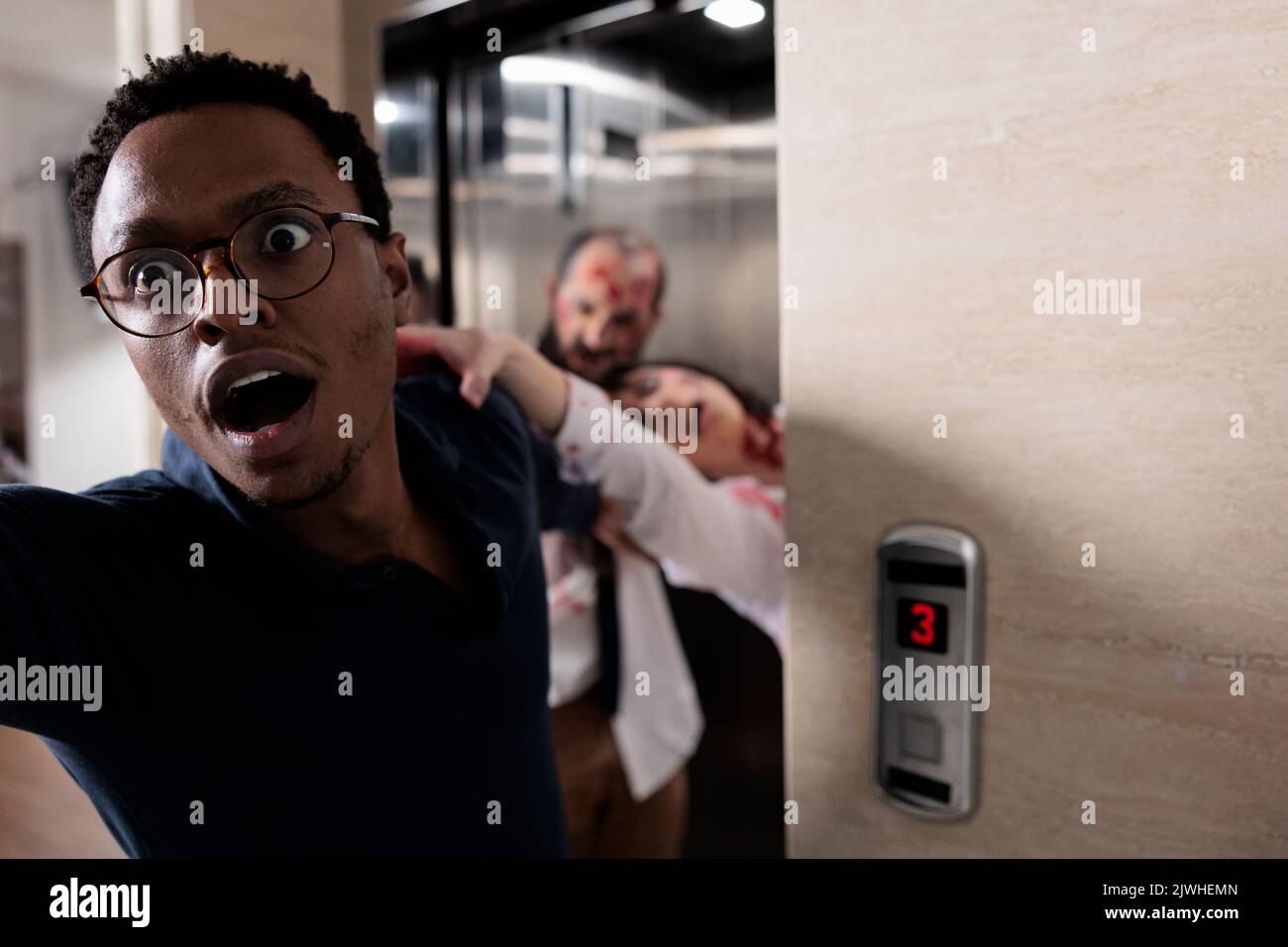 Frightened man running from evil zombies, trying to escape elevator ...