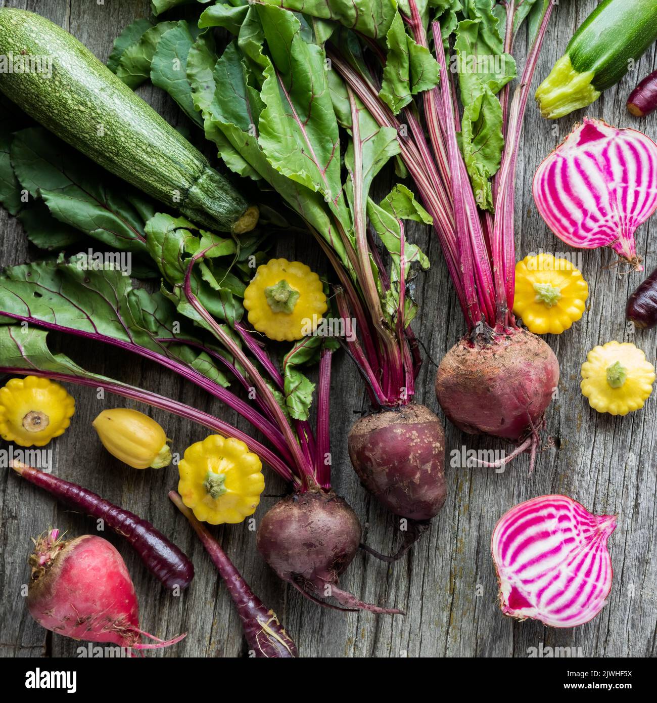 Top down view of an assortment of root vegetables on a rustic wooden ...