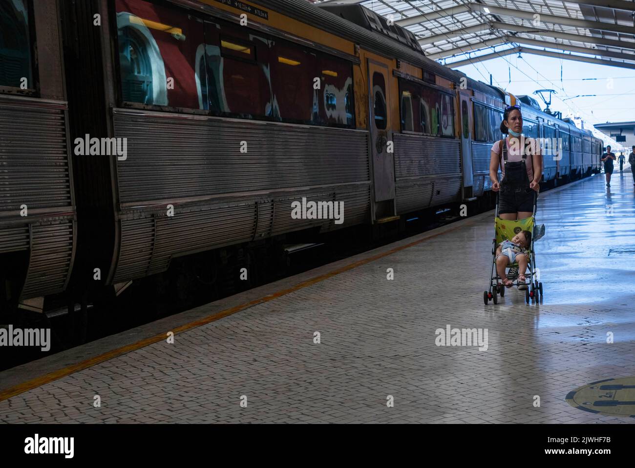 A woman pushing a baby stroller seen walking on the platforms of the ...