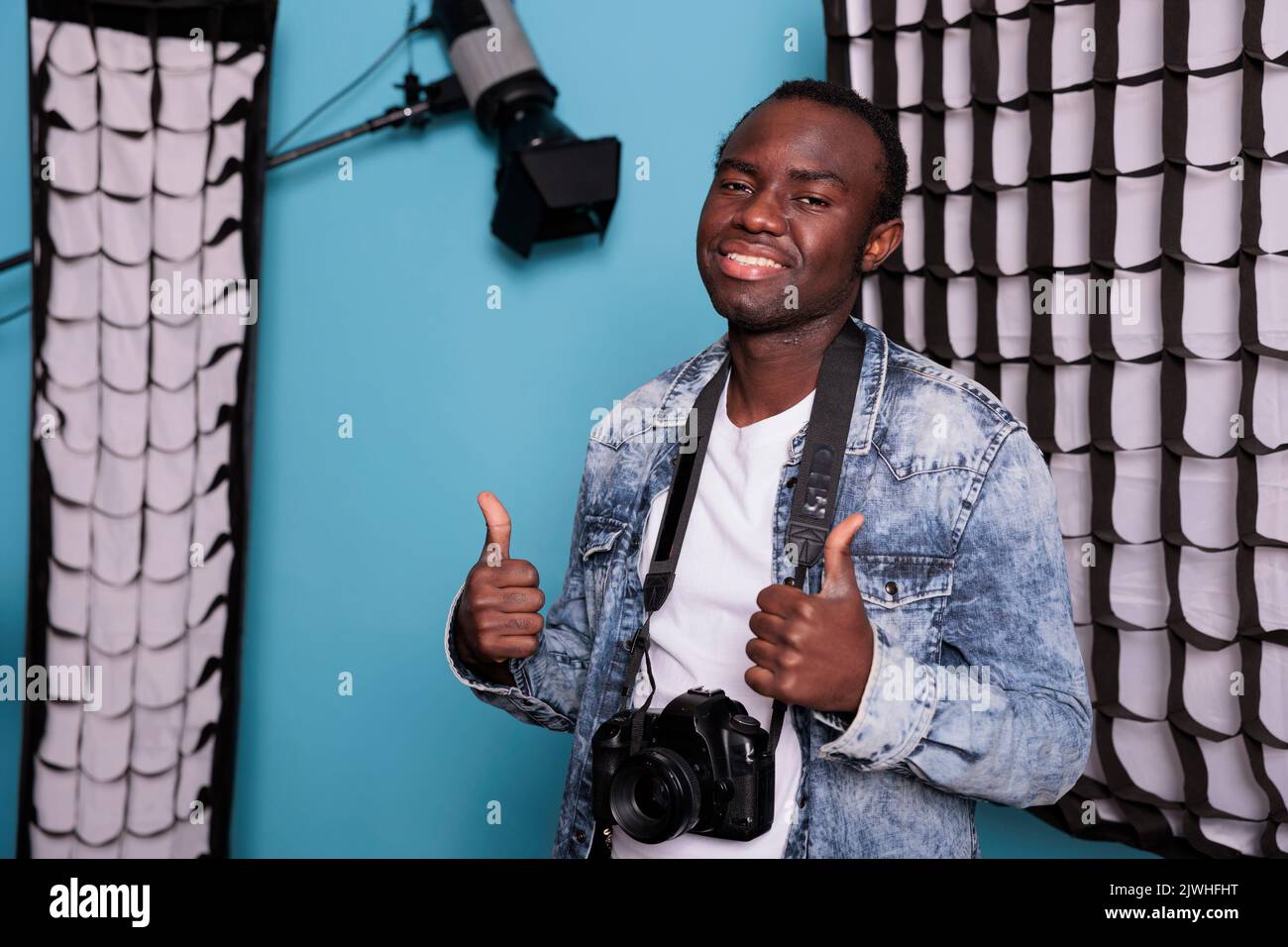 Happy photographer showing approval hand gesture while standing in ...