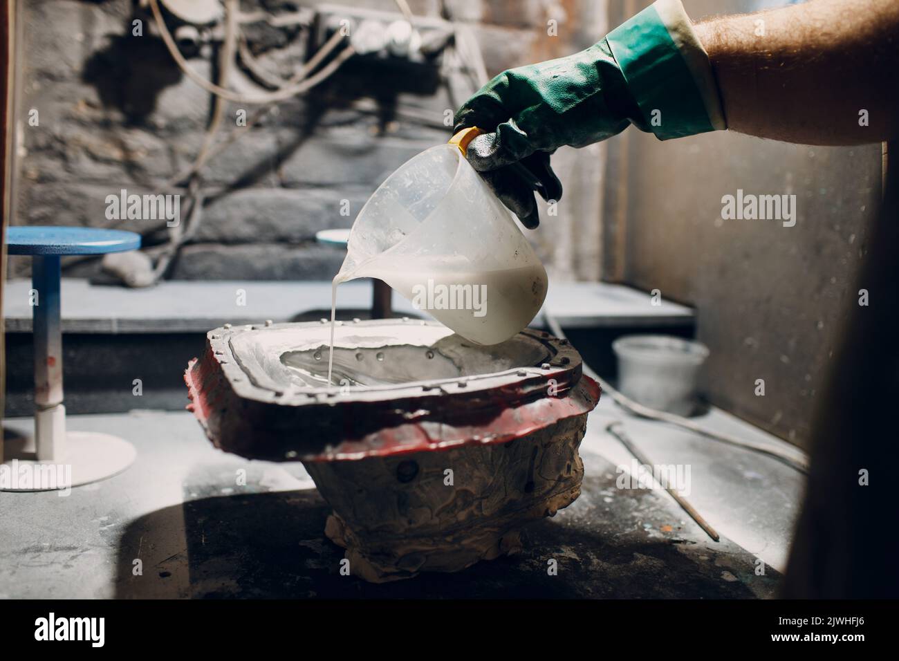 Artisan craftsman pour liquid plastic mask based on plaster cast ...