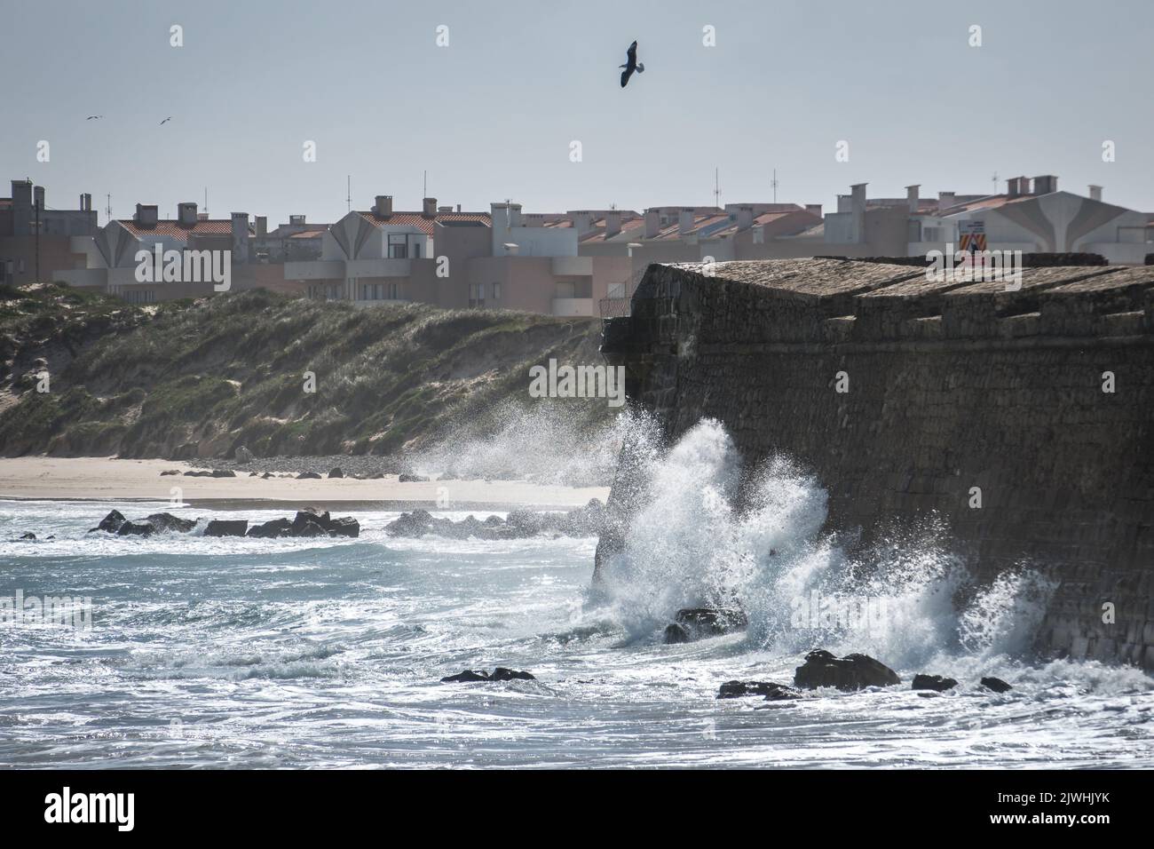 A scenic shot of sea waves slamming against a seawall of Nazare in ...