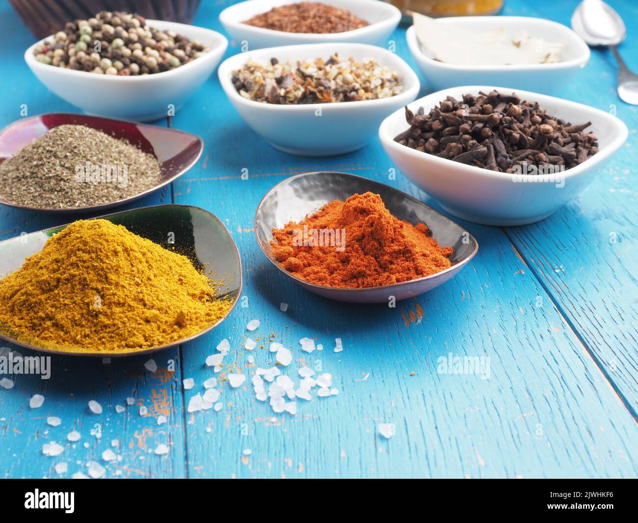 Assortment of organic spices and herbs on a blue wooden table, healthy ...