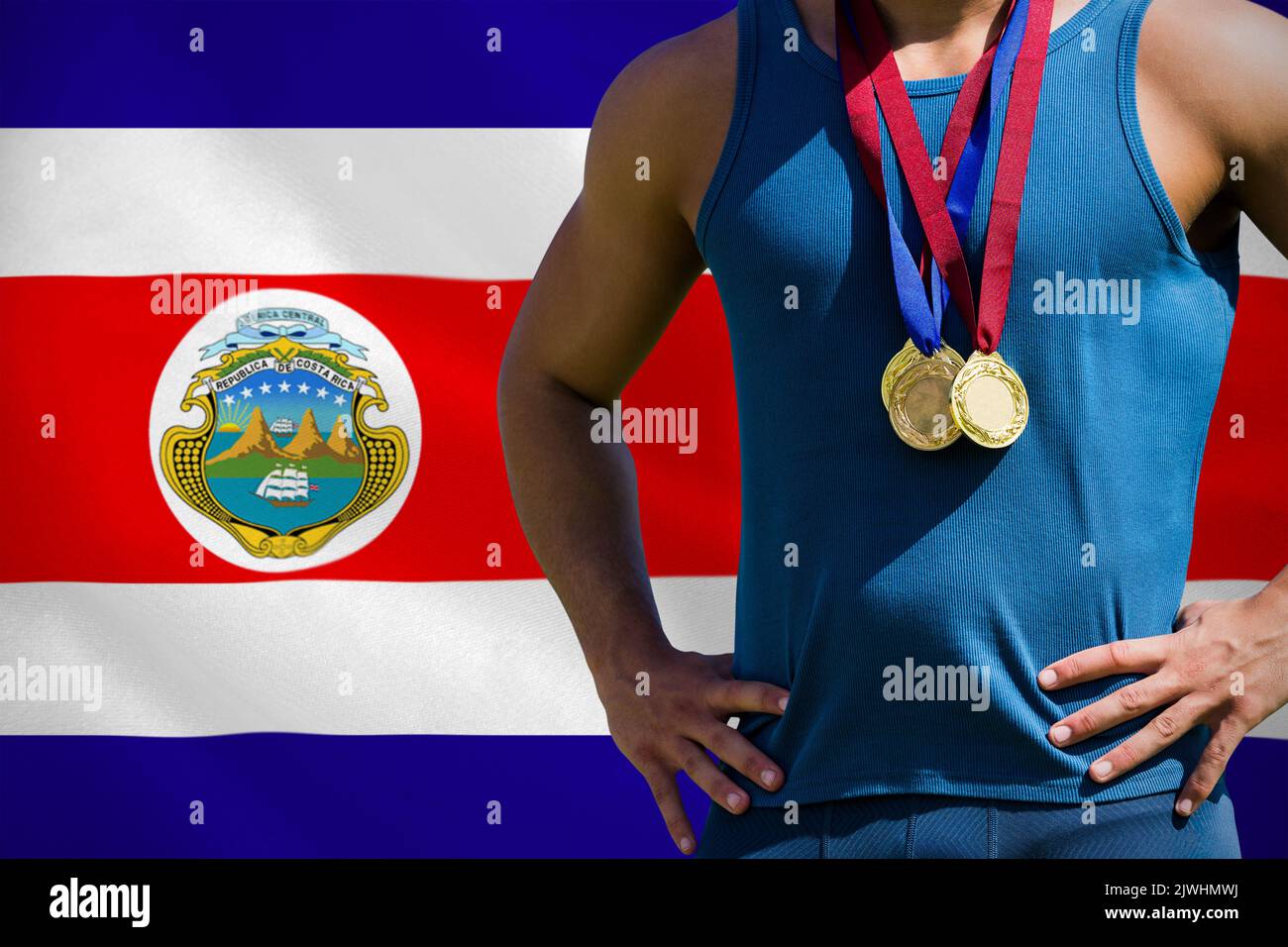 Midsection of male medalist standing with hands on hip against Costa ...