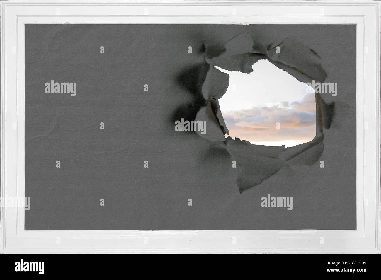 Rip on wall showing bright sky Stock Photo - Alamy