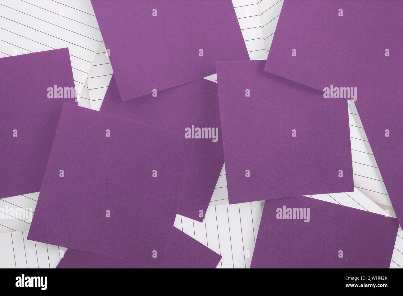 Purple paper strewn over notepad paper Stock Photo - Alamy