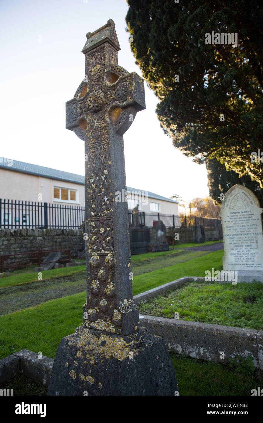 Tombstone by tree against sky Stock Photo - Alamy