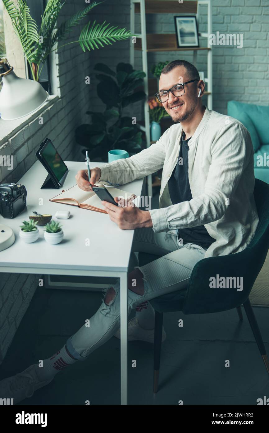 Portrait of a smiling handsome young man wearing eyeglasses checking ...