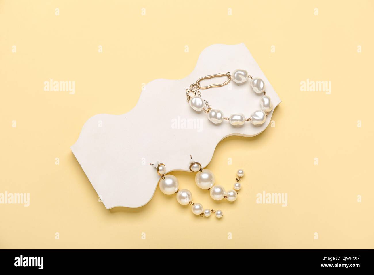 Showcase pedestal with pearl jewelry on color background Stock Photo ...