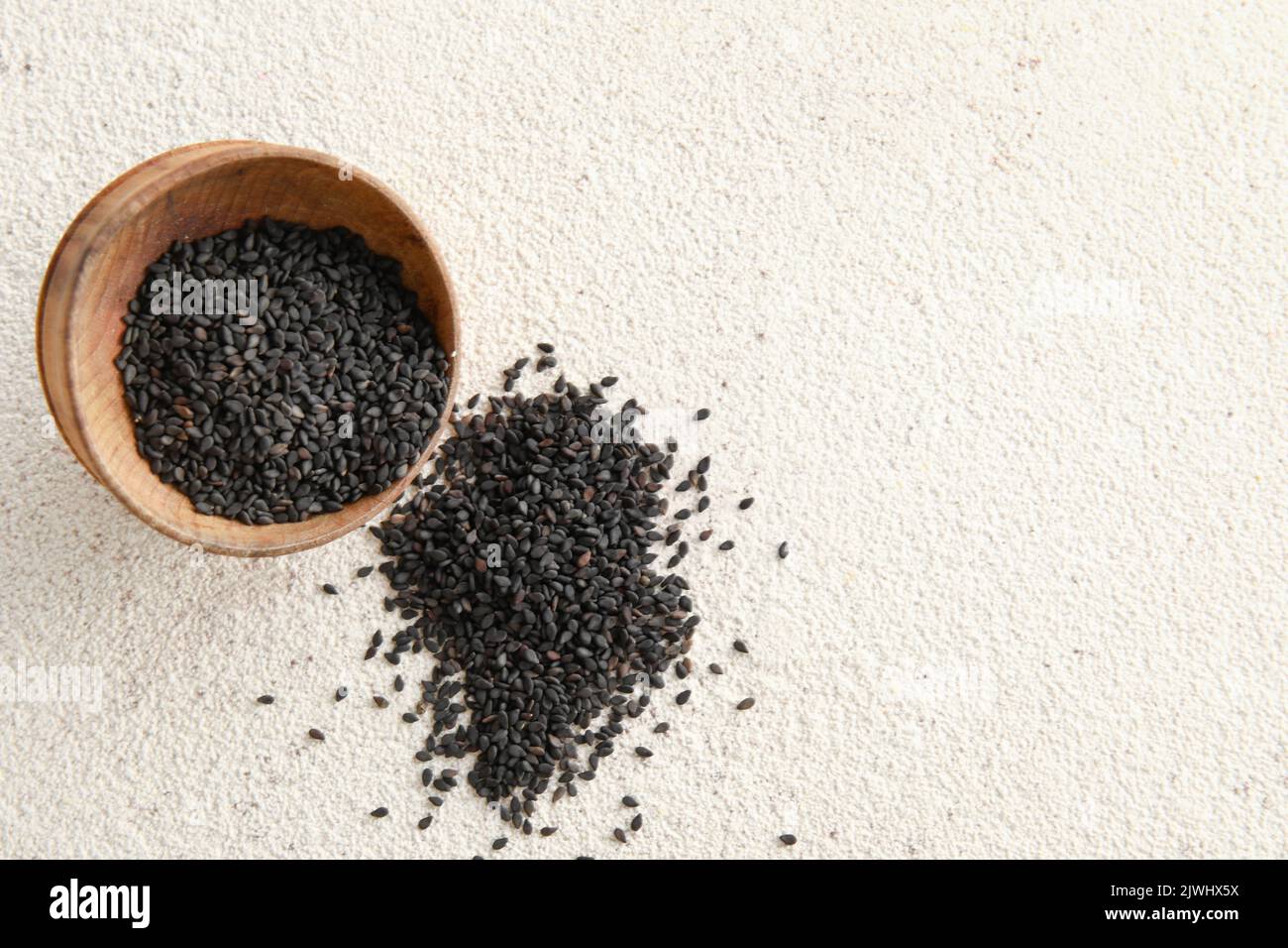 Bowl of black sesame seeds on light background Stock Photo - Alamy