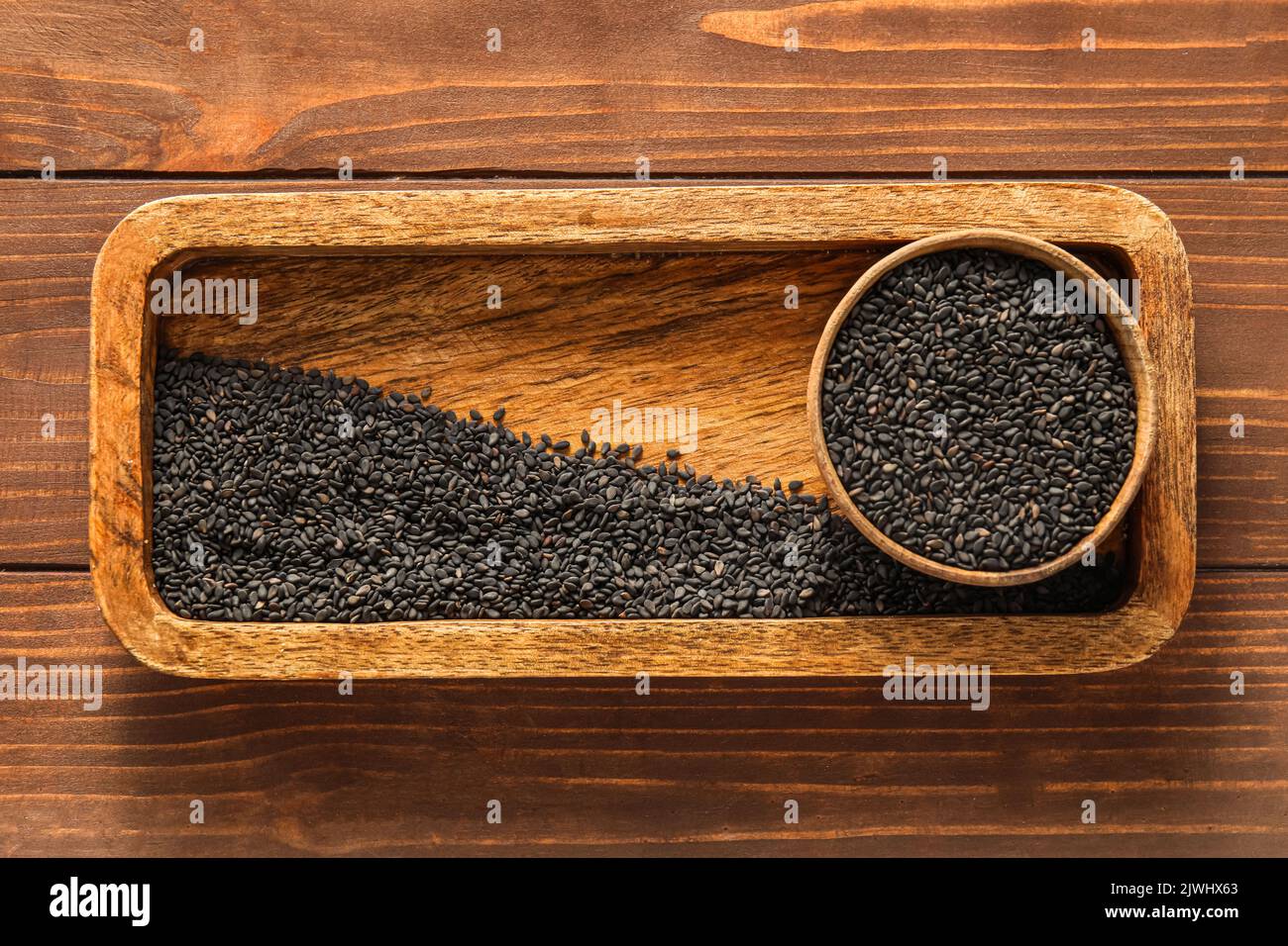 Board with bowl of black sesame seeds on wooden background Stock Photo ...