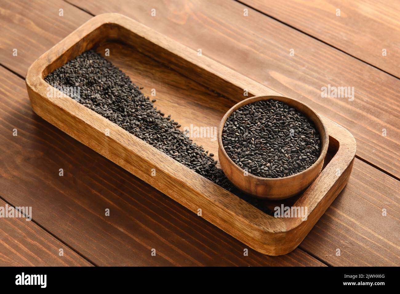 Board with bowl of black sesame seeds on wooden background Stock Photo ...