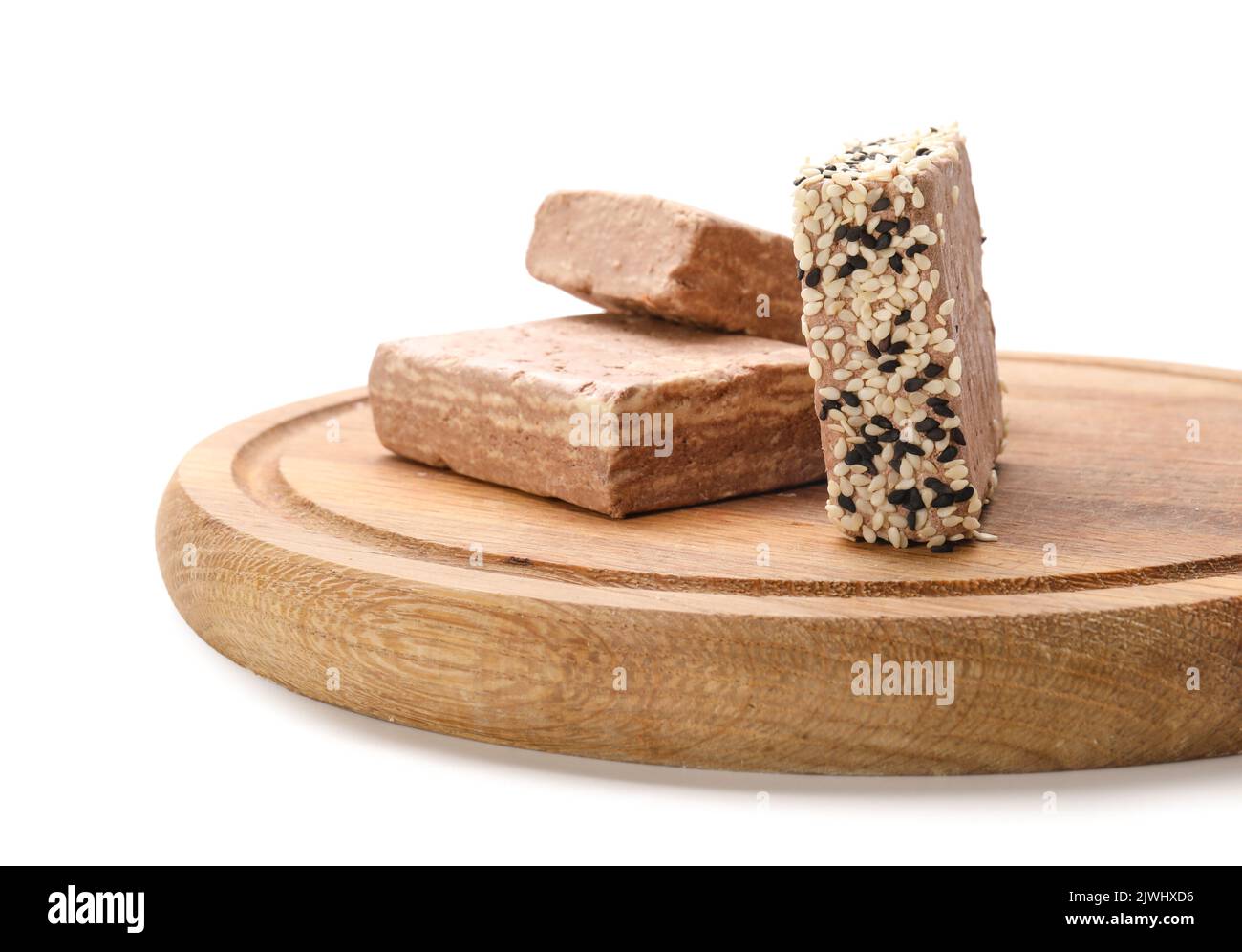 Wooden board of tasty sesame halva on white background, closeup Stock ...