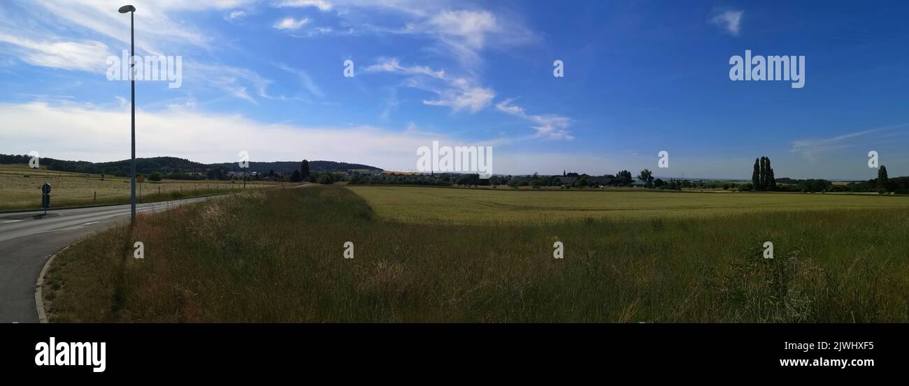The panoramic view of the road passing by the green landscape under the ...