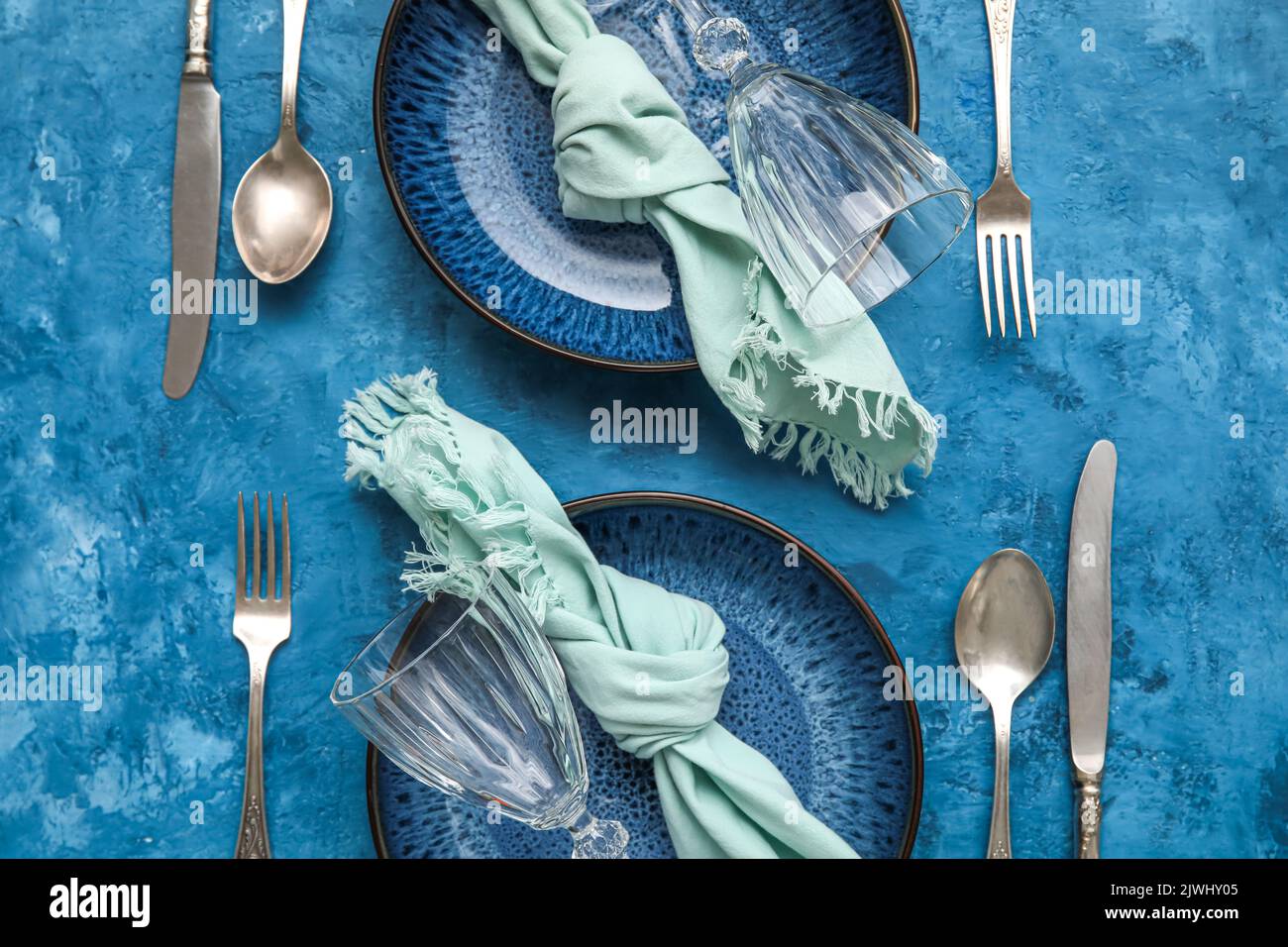 Stylish table setting with plates, napkin and cutlery on blue ...