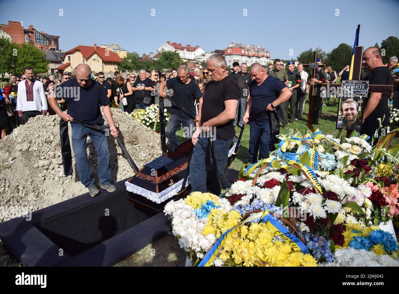 Lviv, Ukraine. 24th Aug, 2022. Undertakers lower the coffin with the ...