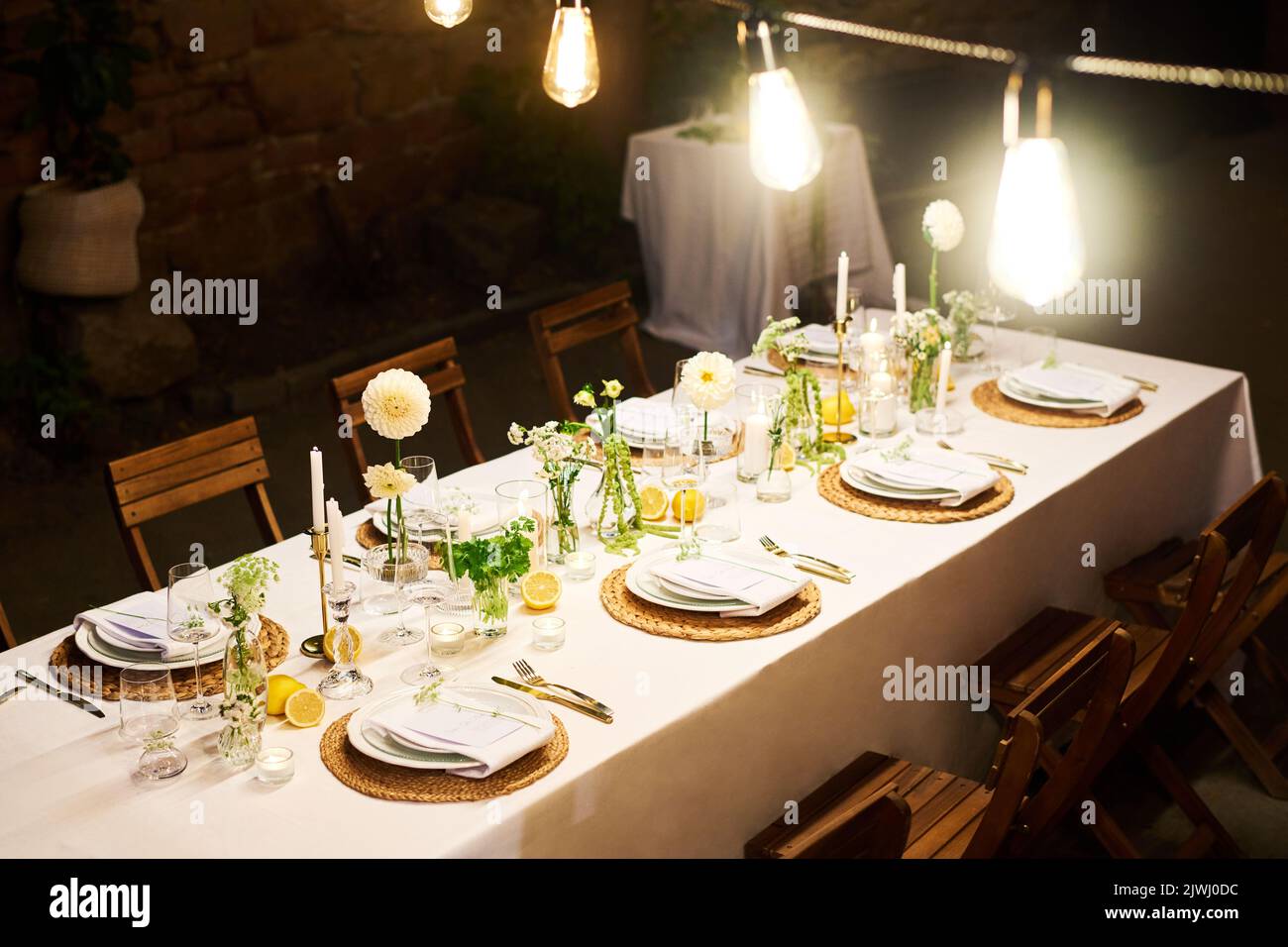 Several bright lamps hanging over festive table served for wedding ...