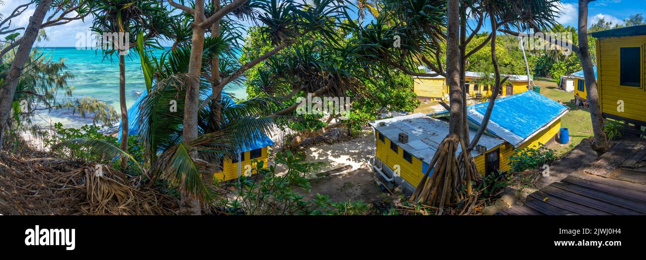 View towards ocean over yellow bungalows at family run homestay in ...