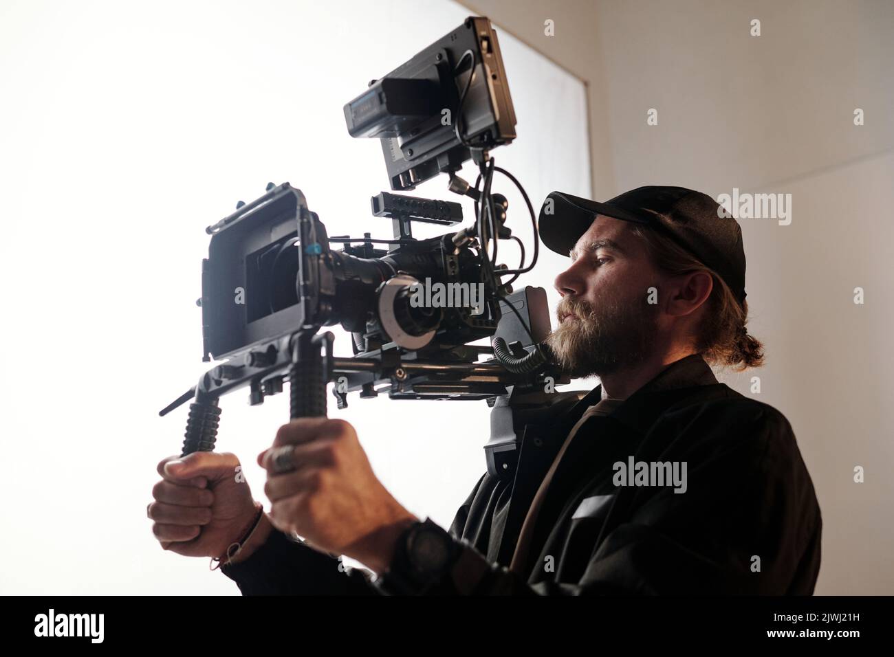 Young serious man in smart casualwear shooting commercial in production ...