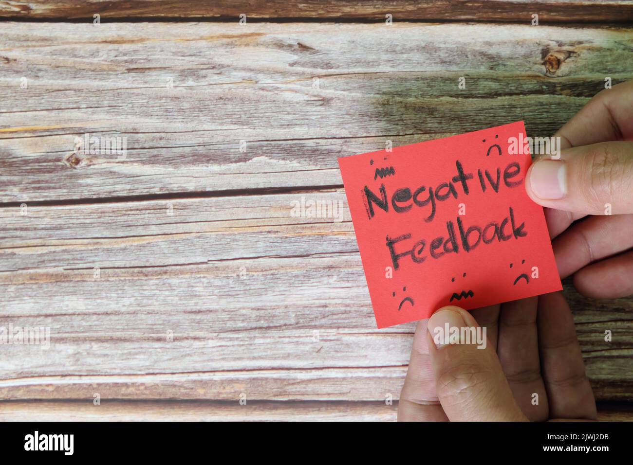 How to handle customer negative feedback concept. Hand holding red note ...