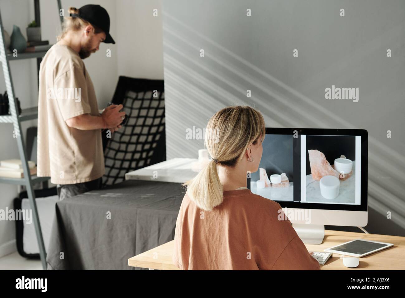 Back view of young creative photographer looking through new images on ...