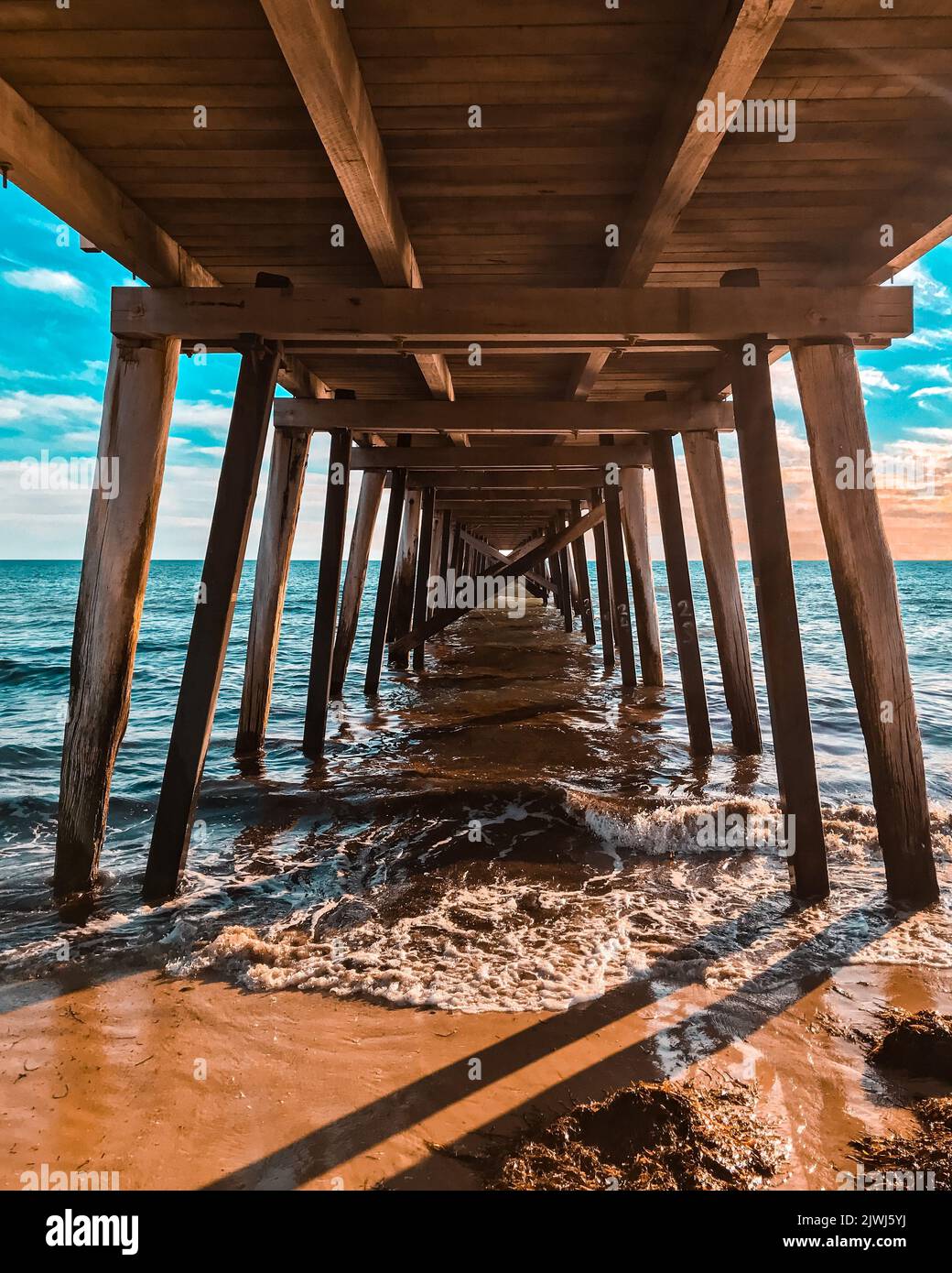 A vertical shot of the underside of a wooden pier in a beach Stock ...
