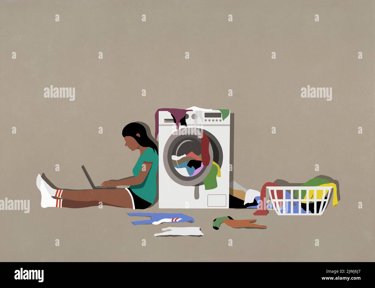 Girl using laptop and doing laundry at clothes dryer Stock Photo - Alamy